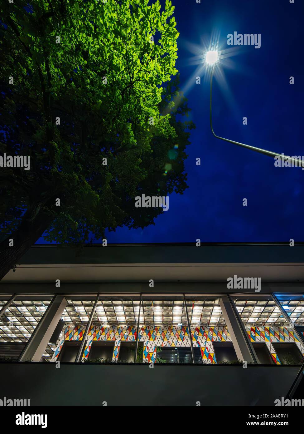 Modern building with diamond-shaped glass panels, brightly lit interior ...