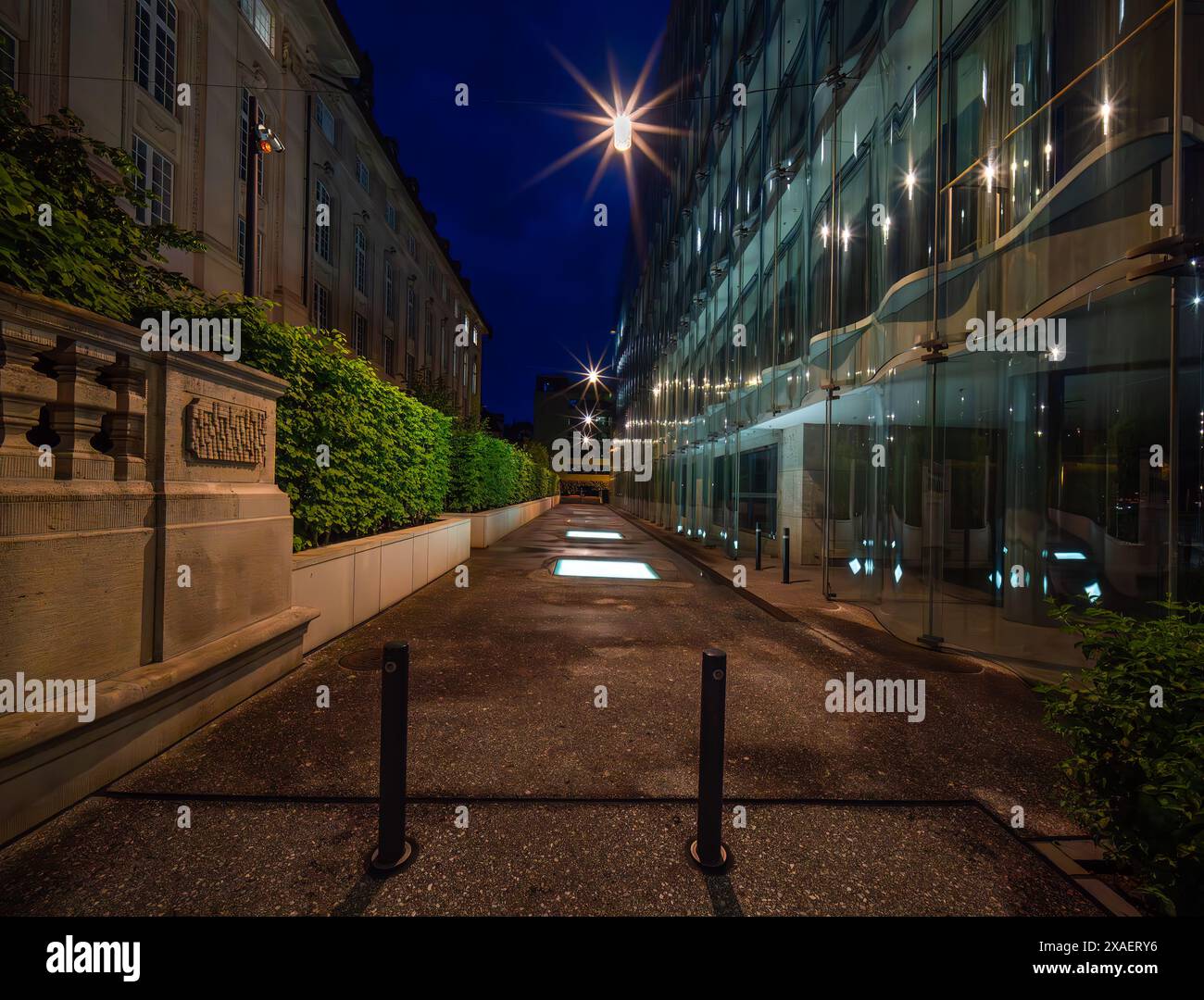 Lit urban alleyway in Zurich, Switzerland, at night with modern and ...
