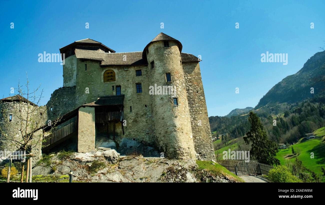 A large stone building with a steeple sits on a hillside. The building ...