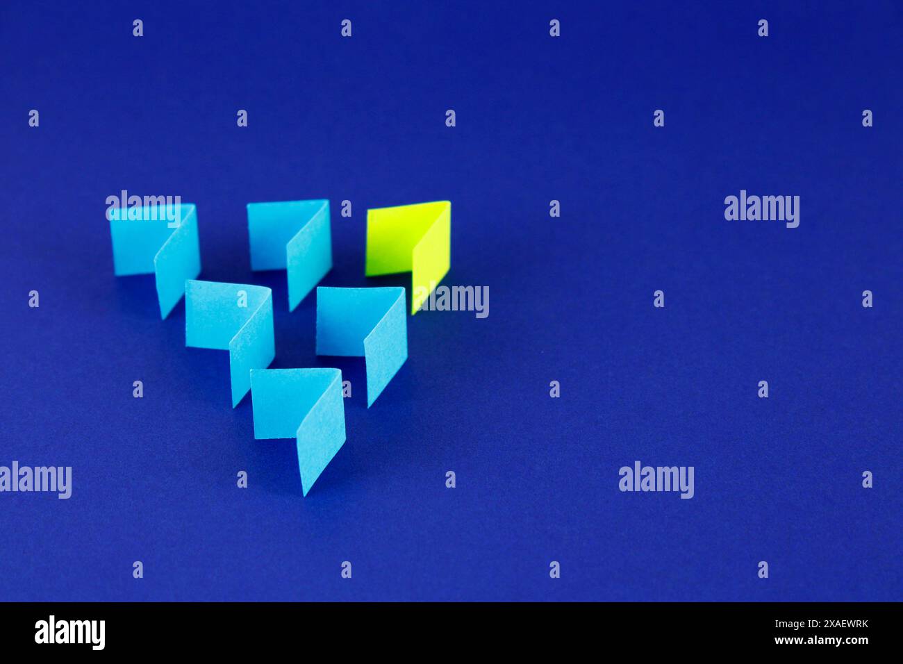 Folded papers forming a triangle and arrow and where one of them is ...