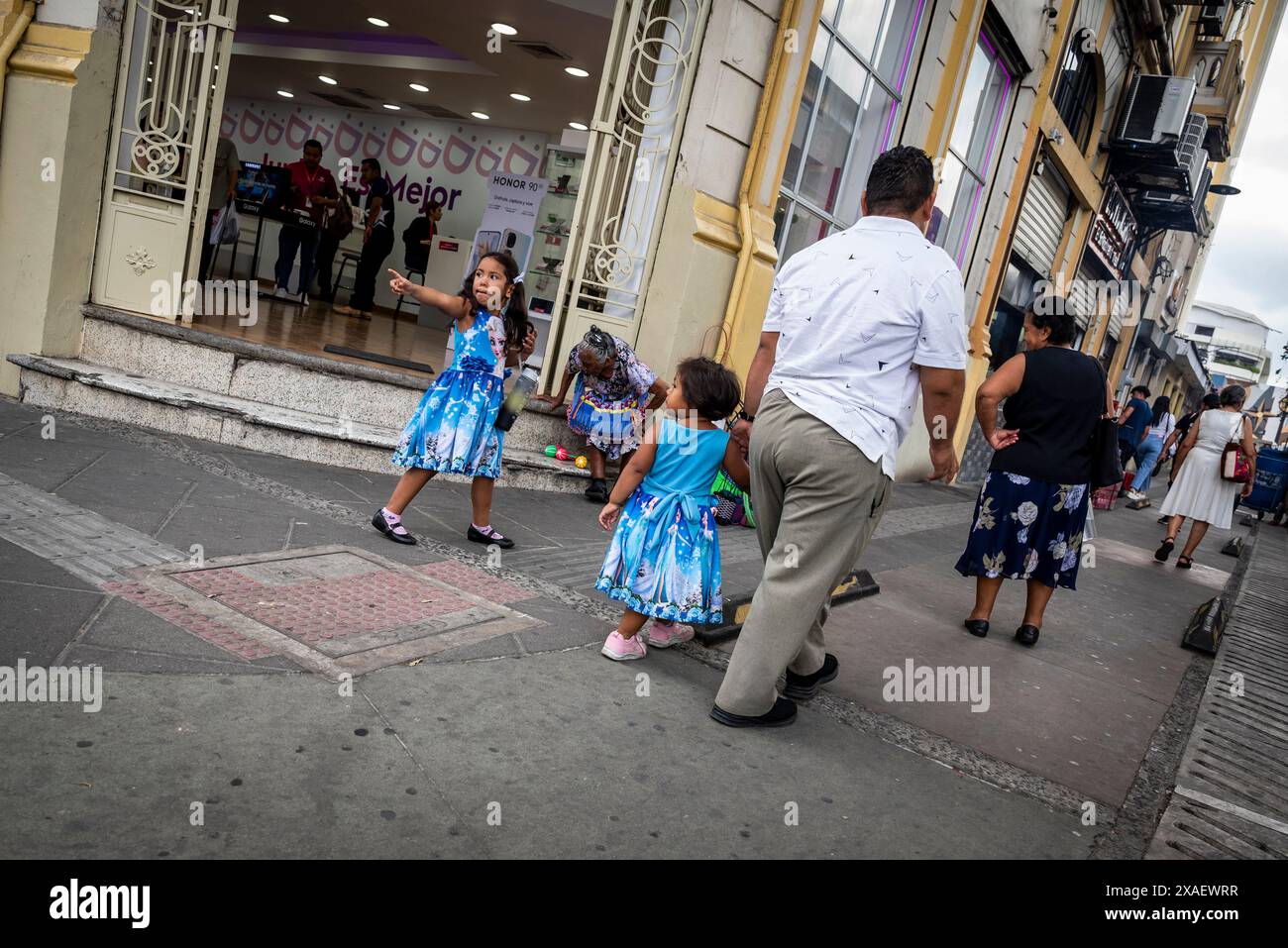 Street scen in the city centre - father and two girls in identical ...