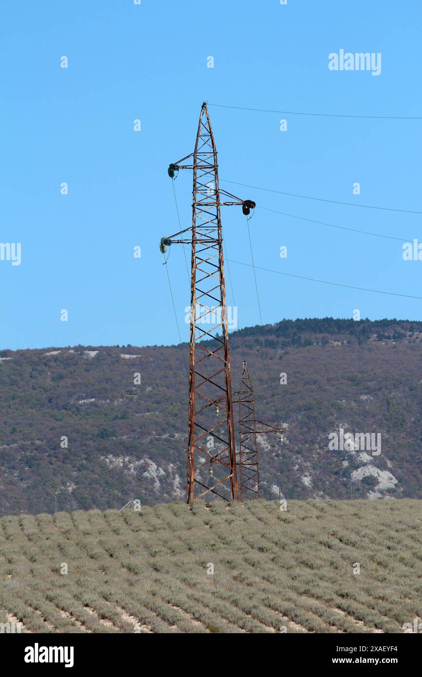 Rusted overhead power line transmission towers with three electrical ...