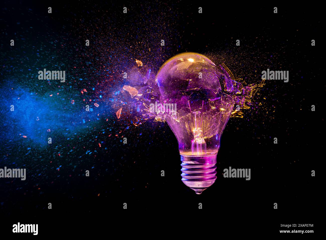 Colorful light bulb exploding glass flying everywhere black background ...