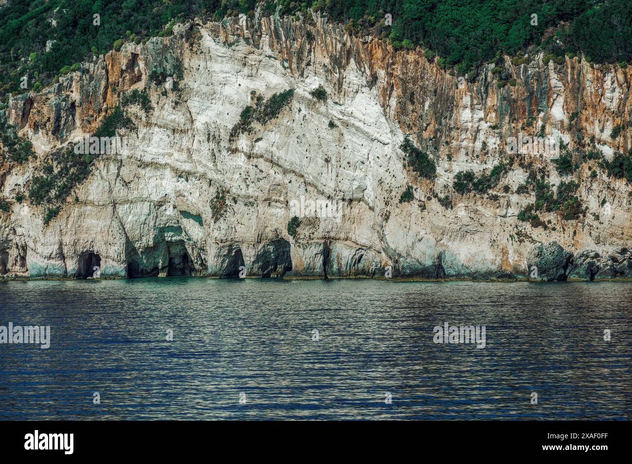 Natural cave formation on a rocky hill stretching to the sea in ...