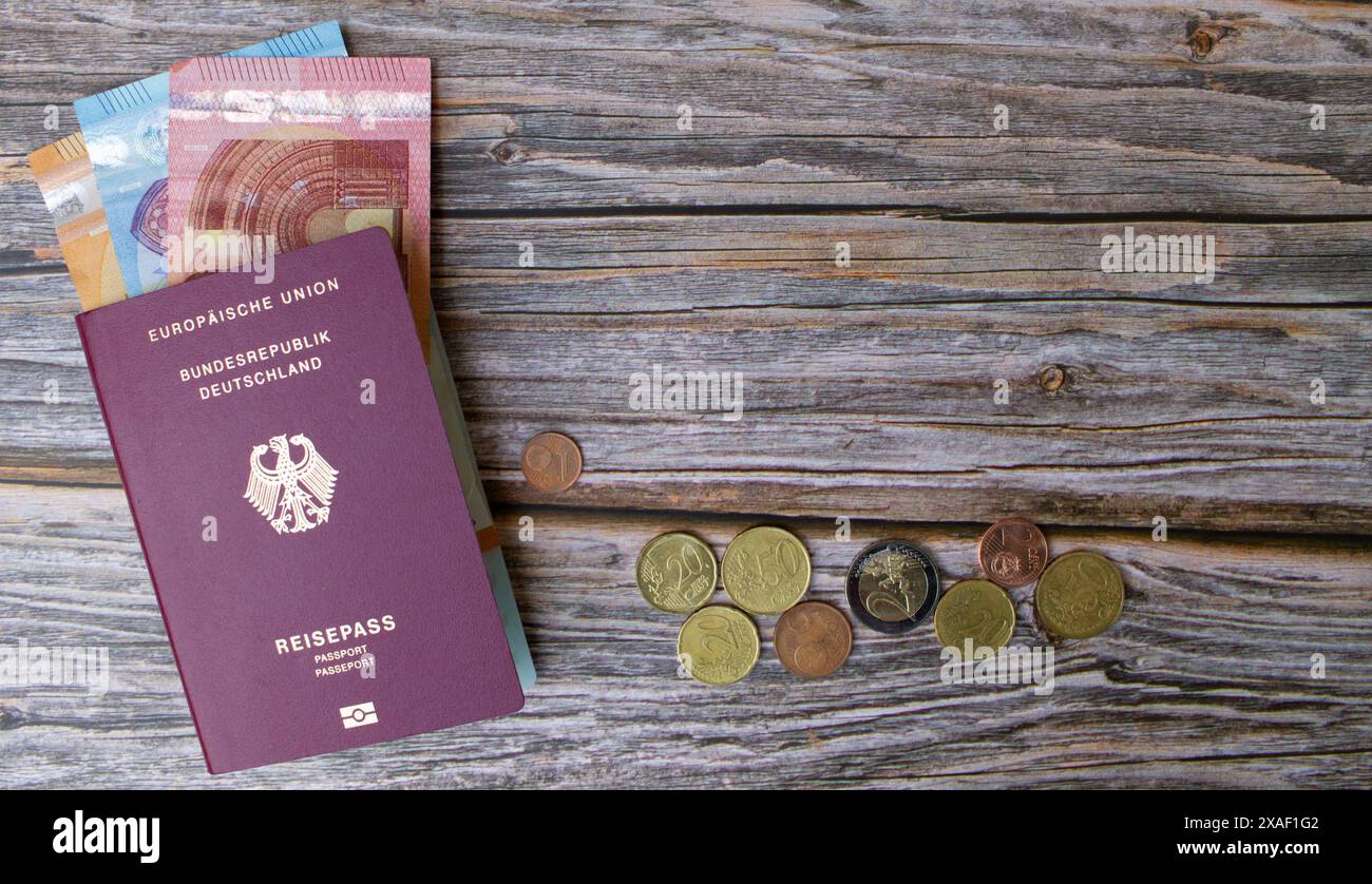 Flatlay photo of german travel passport with euro banknotes inside it ...