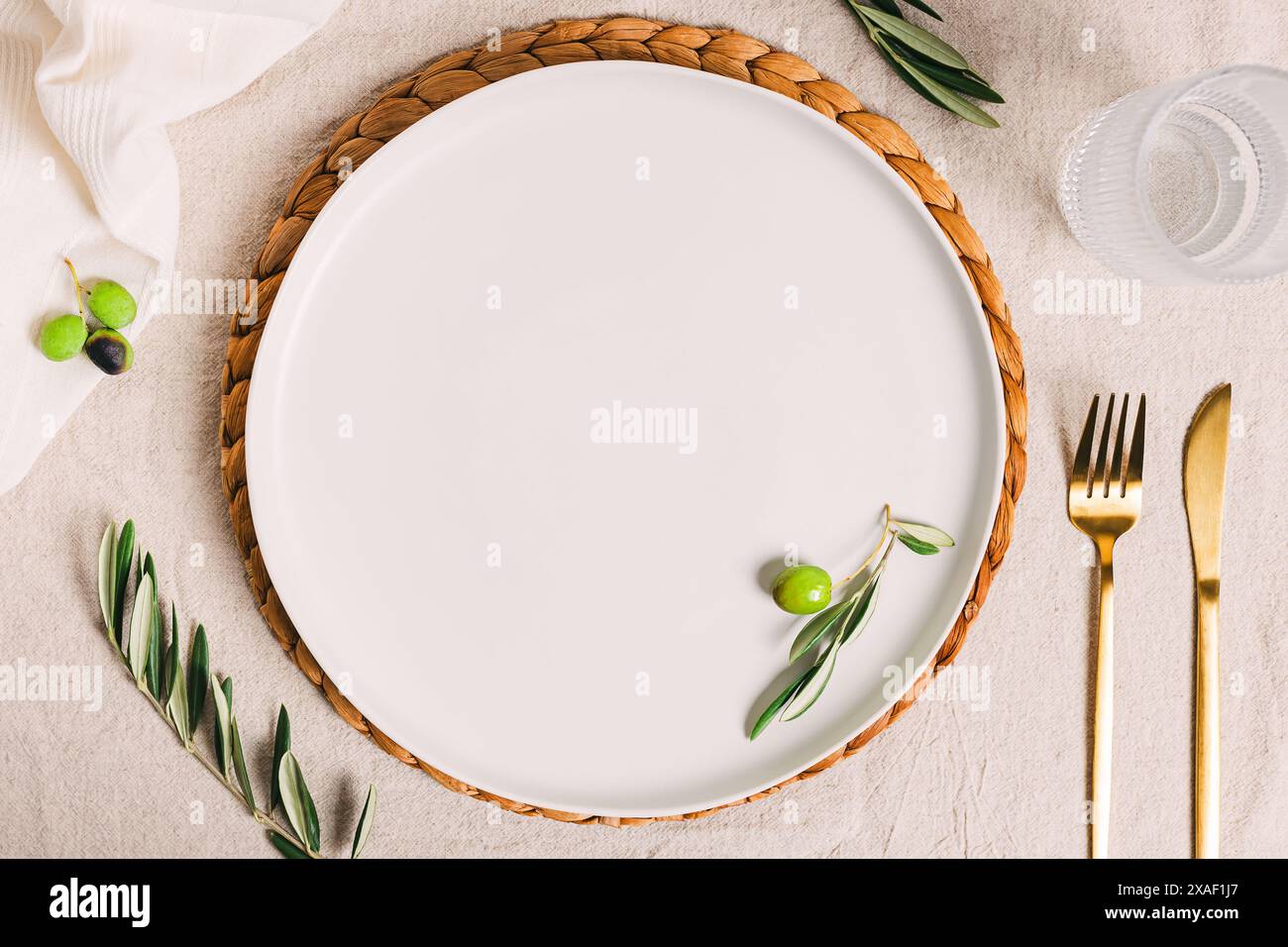 Empty stoneware dinner platte and small green olive branches, elegant ...