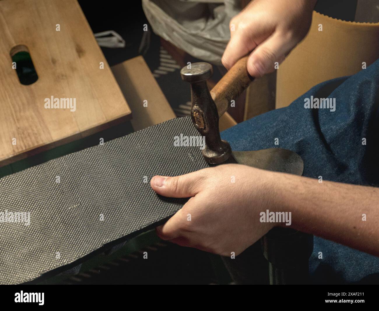 Shoemaker's hands with hammer repairing shoe sole. Trades, business ...