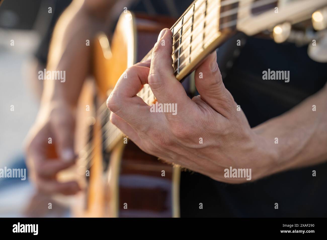 Close-up of a musician’s hands playing an acoustic guitar. This image ...