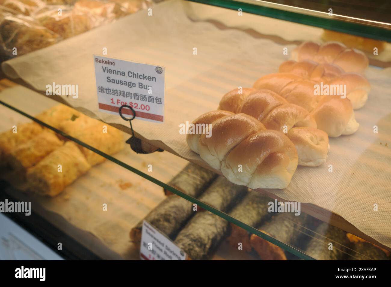 A Viennese Chicken Sausage Bun, behind glass in a Singapore Food Market ...