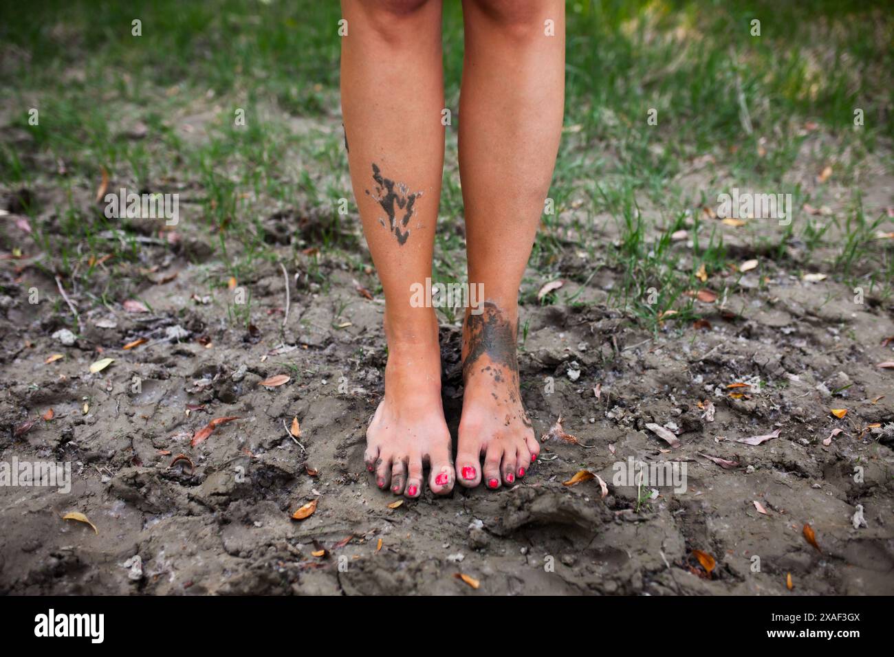 A detailed image focusing on a person's muddy feet in the outdoors ...