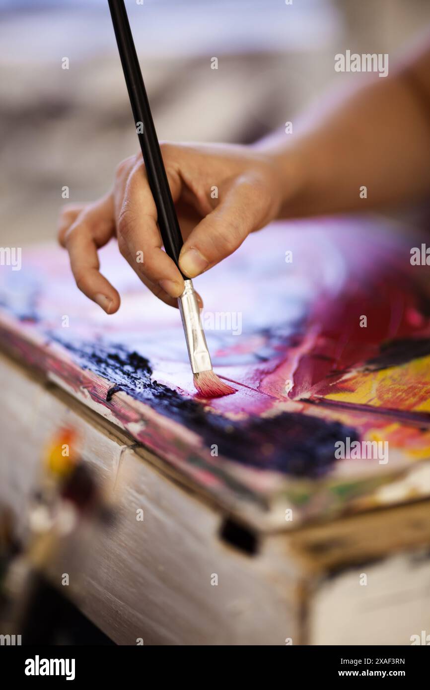Hand using brush on an artistic painting. Female artist creating art ...