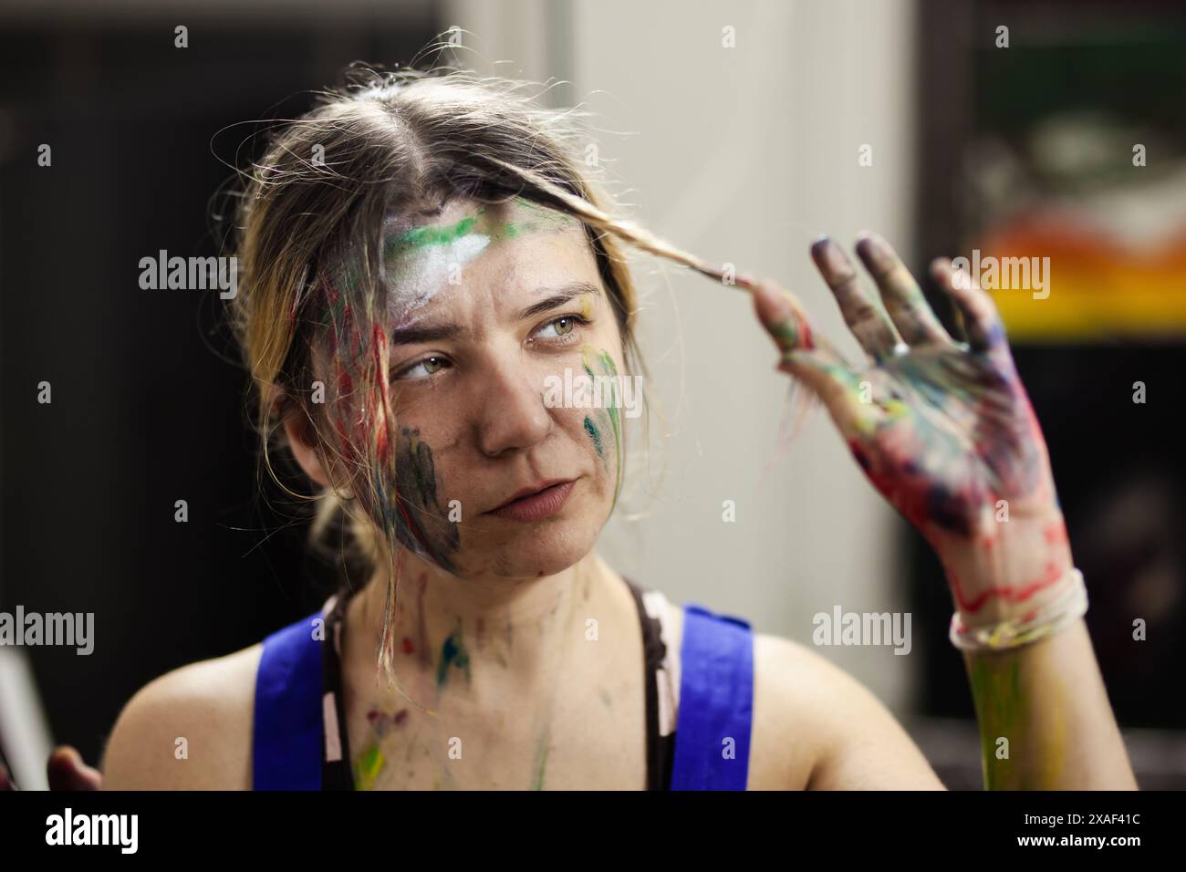 Portrait of a female artist. Girl with clumsy clorful painted face ...