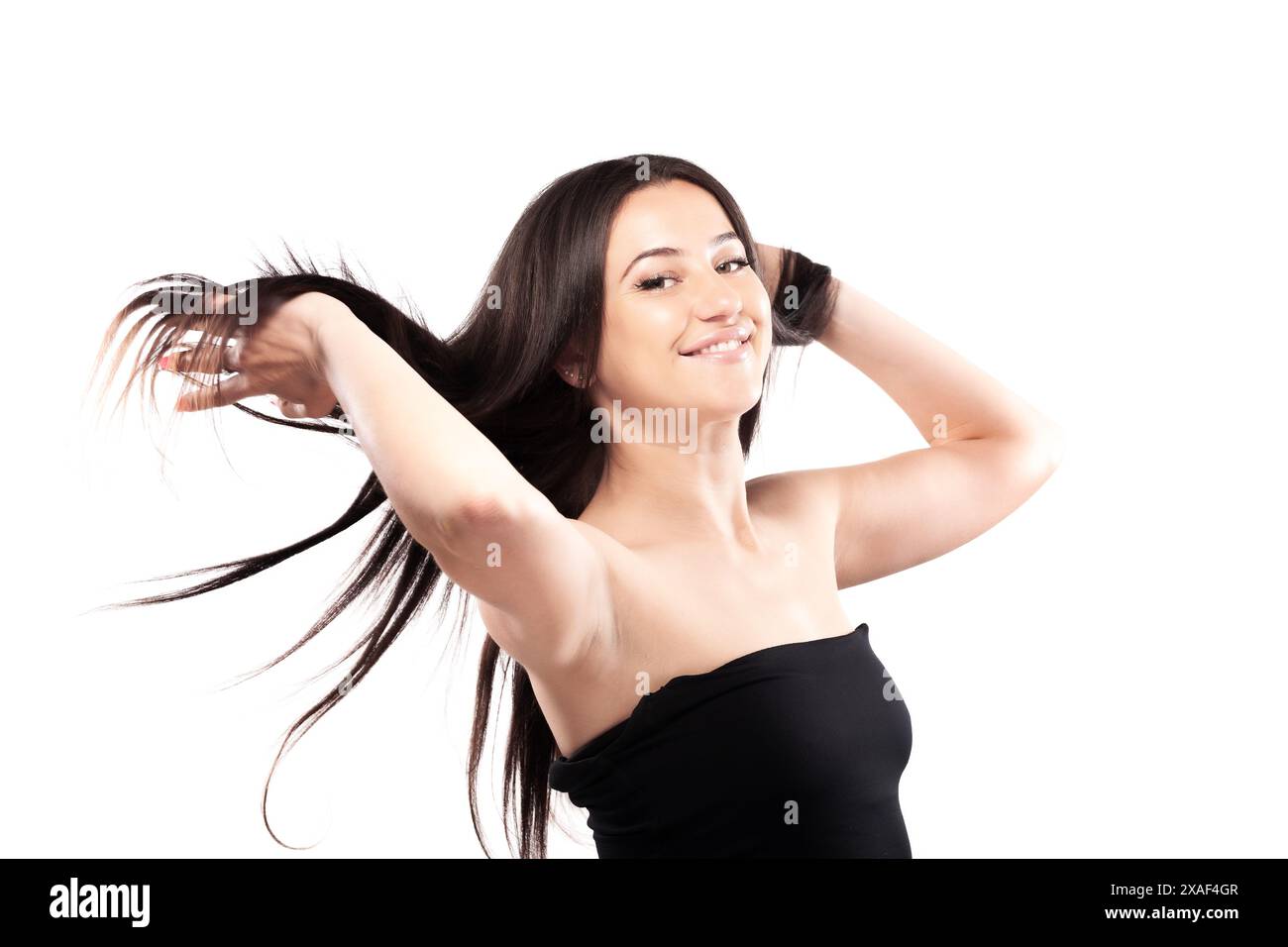 Young woman with long dark hair. Standing confidently in against white ...