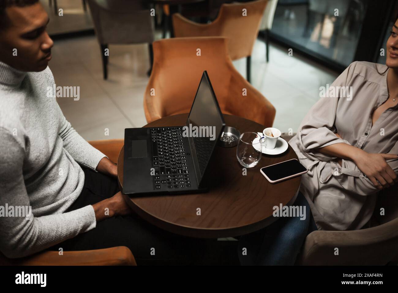 Friends at a cafe after work. Business colleagues working on laptop and ...