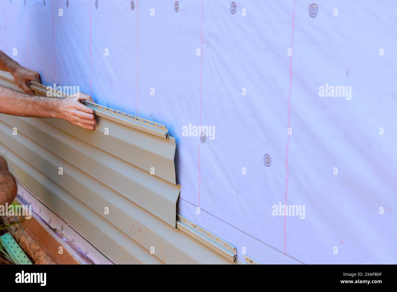 An installation process for vinyl PVC siding on new home facade by ...