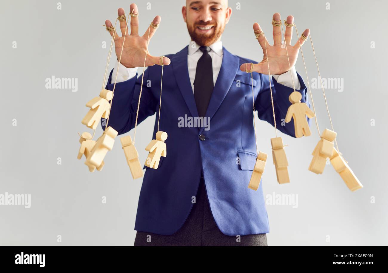 Businessman playing with puppets illustrating concept of manipulation ...