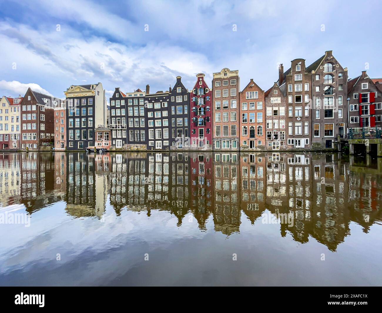 Traditional Dutch architecture buildings on Damrak canal in Amsterdam ...