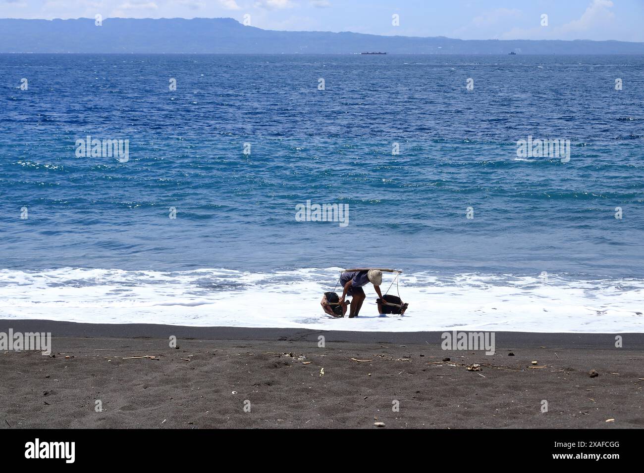 Kusamba, Bali in Indonesia - February 08 2024: Farmer collecting water ...