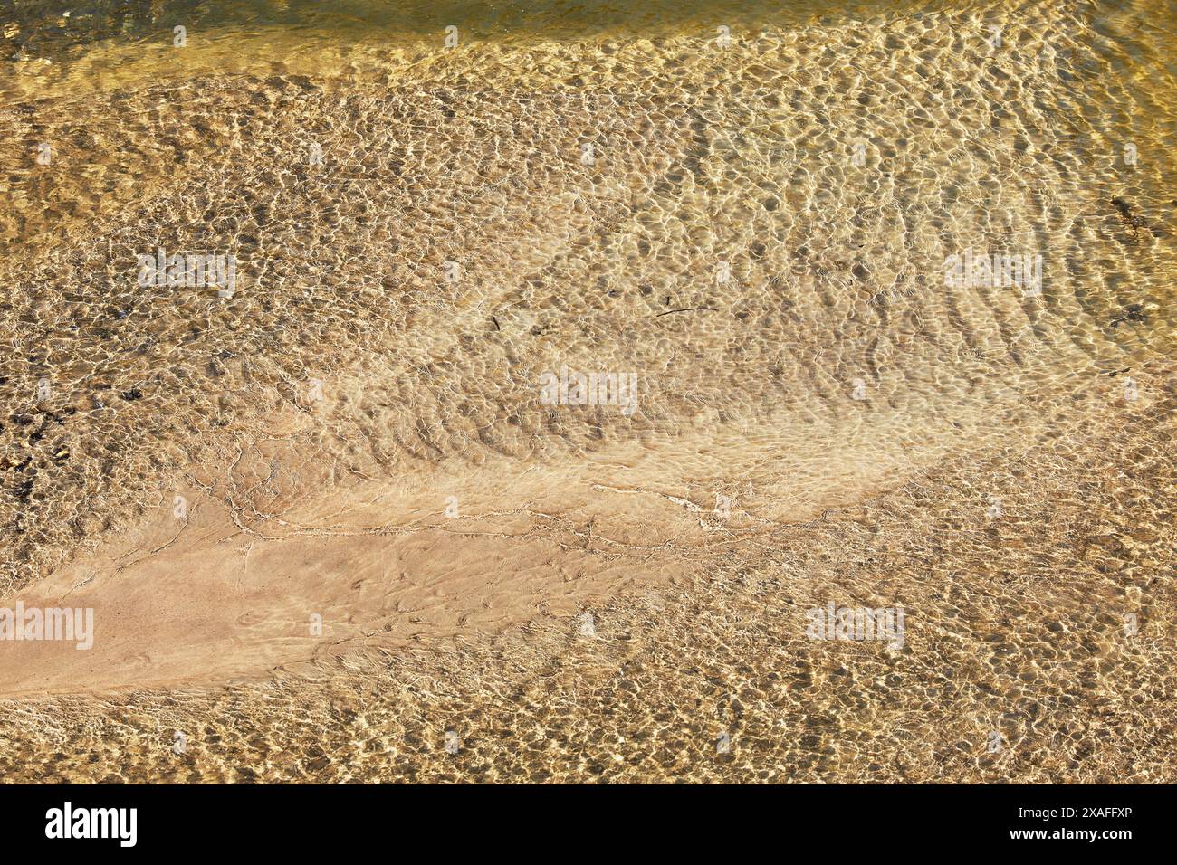Sunlit ripples on the surface of shallow water in Boscastle harbour ...