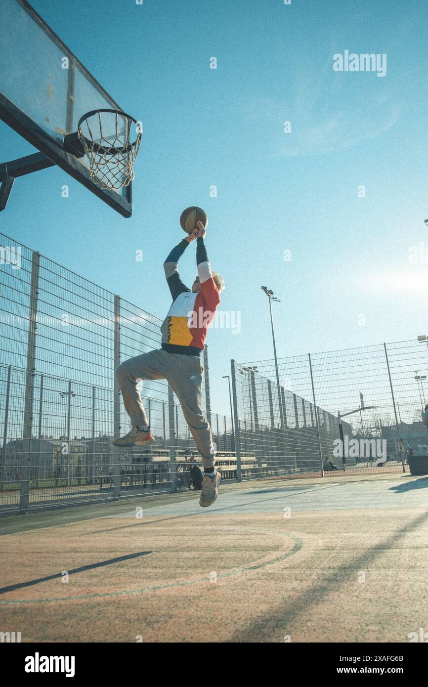 Group of teenagers sitting outside on a basketball field with stands ...