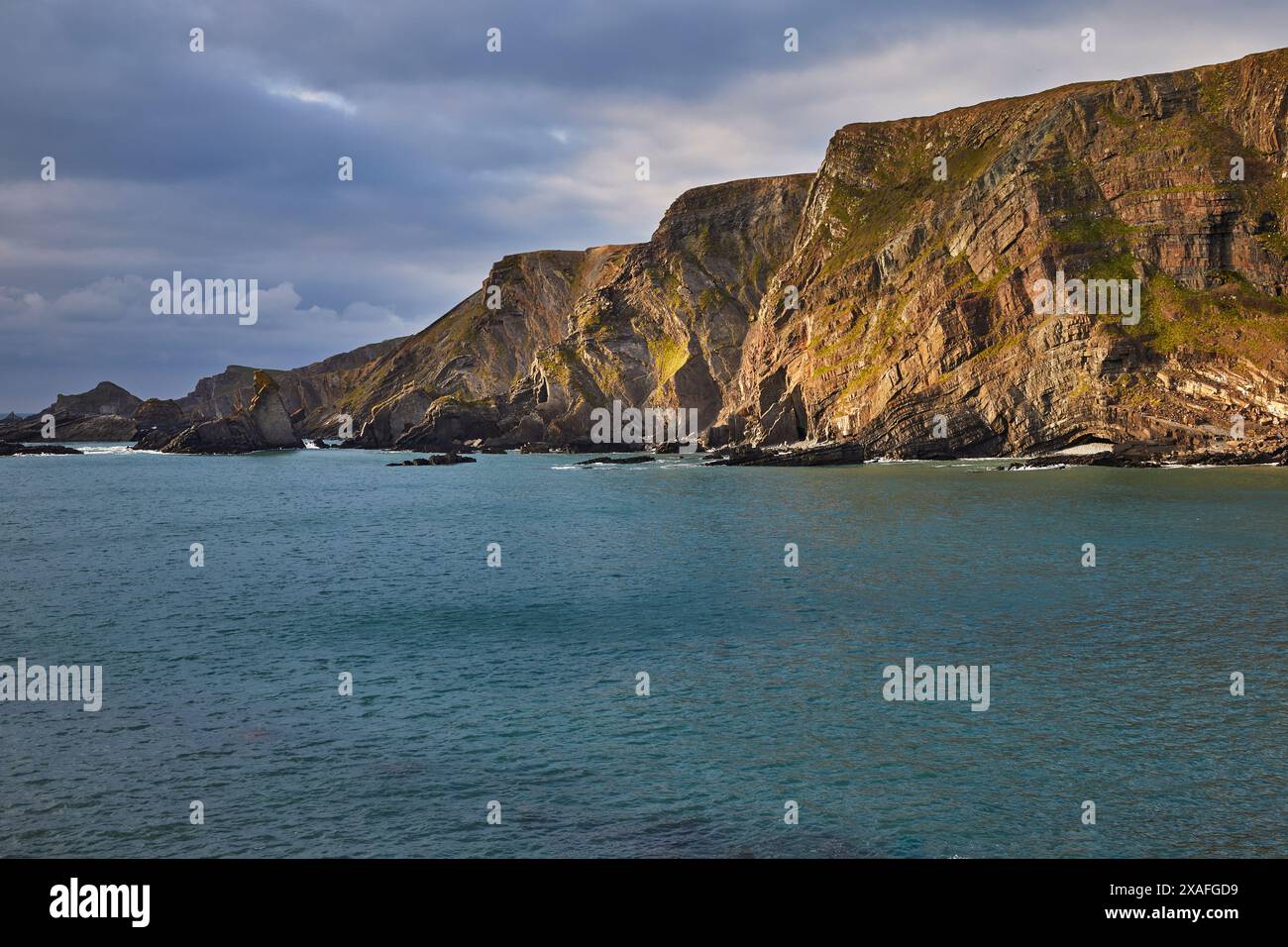 Sunset sunlight shines of rugged cliffs at Hartland Quay, north Devon ...