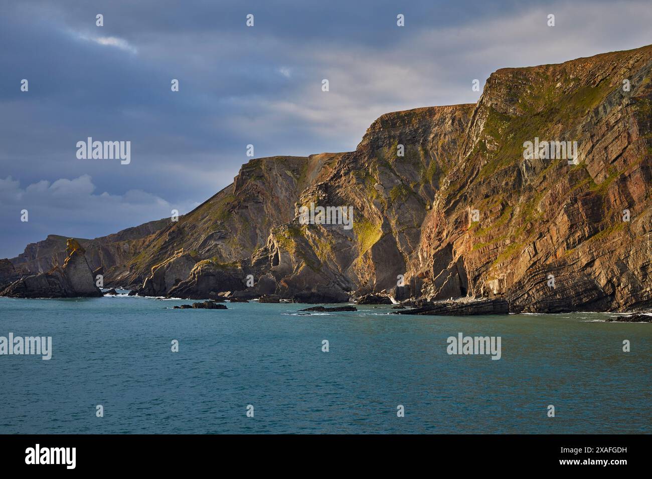Sunset sunlight shines of rugged cliffs at Hartland Quay, north Devon ...