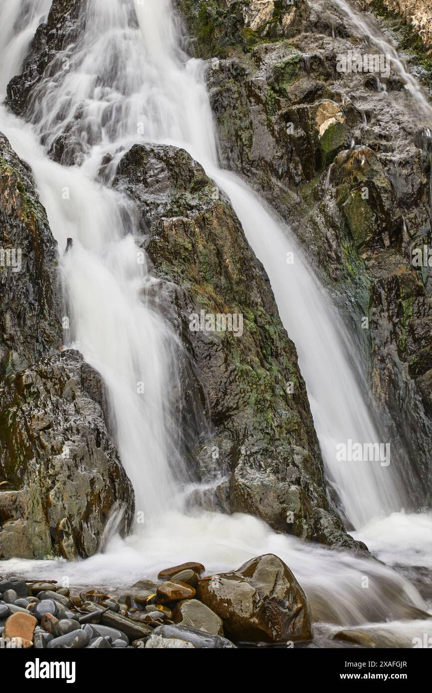 A waterfall cascades down a rock face, at Welcombe Mouth, Hartland ...