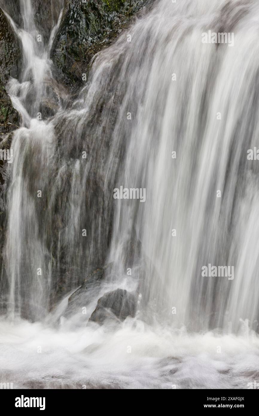 A waterfall cascades down a rock face, at Welcombe Mouth, Hartland ...