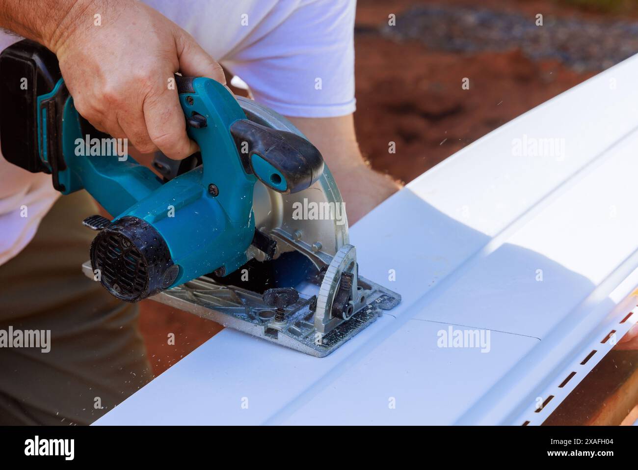 Craftsman cuts vinyl siding panels to desired size before installing ...