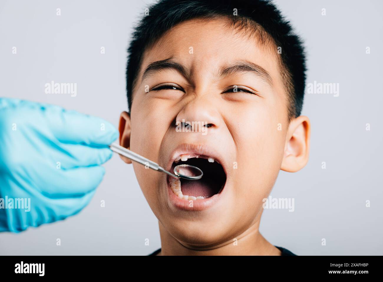 In a pediatric dentist's clinic a doctor examines a child's mouth post ...