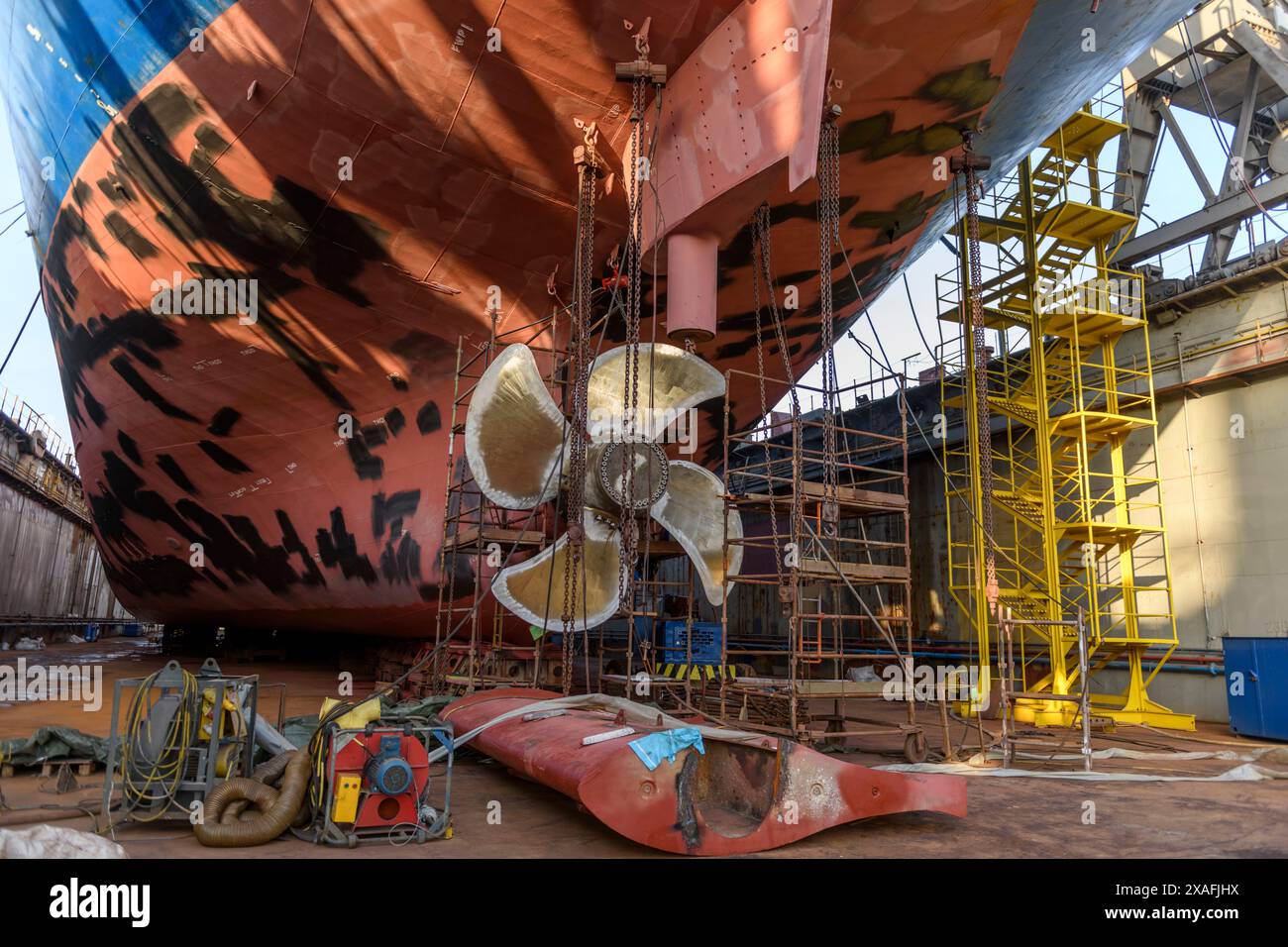 Cargo vessel in dry dock on ship repairing yard. Variable pitch ...