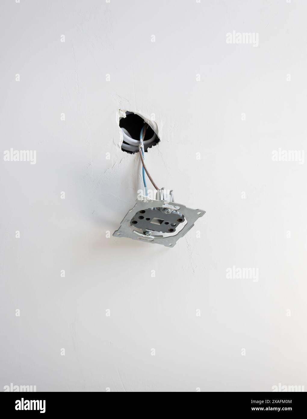 A disassembled metal socket juts out of the wall. The concept of ...