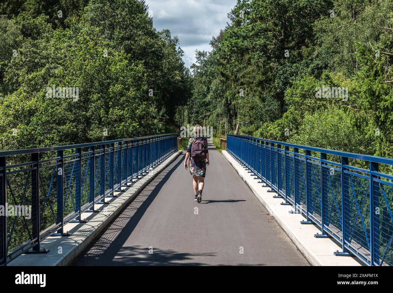 Woman in summer dress walking over a pedestrian and cycling bridge at ...