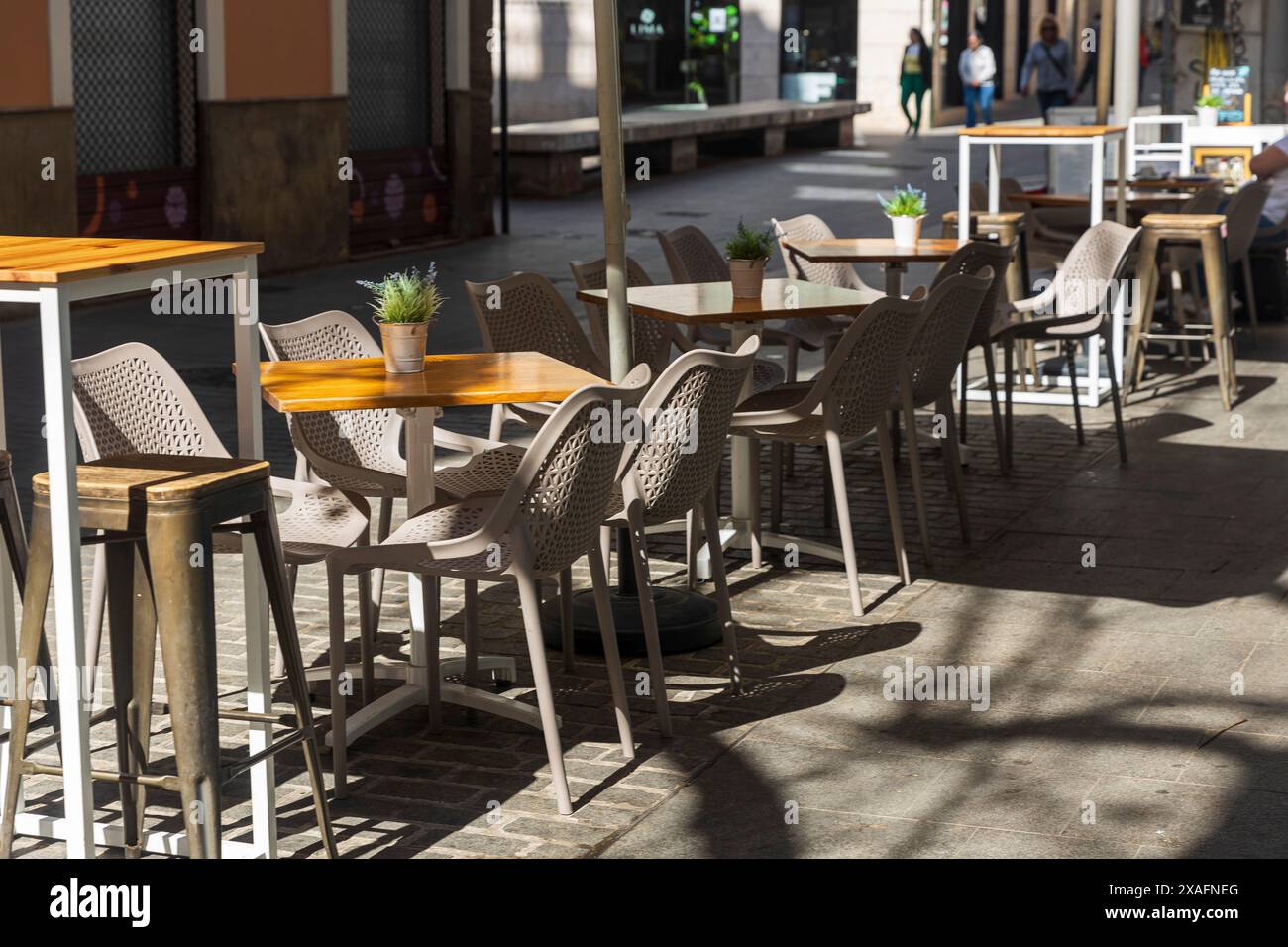 Valencia, Spain, outdoor cafe with tables and wicker chairs. On the ...