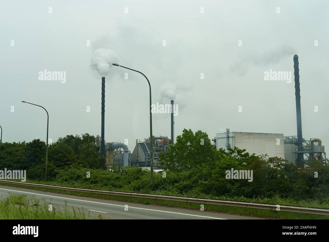 A factory billowing smoke from its tall stacks into the sky, showcasing ...