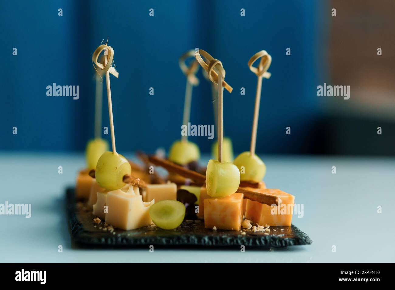 Slicing different types of cheese and grapes. Appetizer with cheese and ...