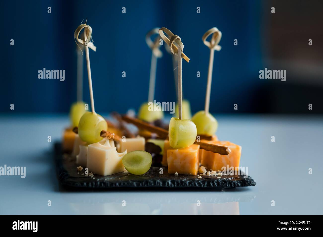 Slicing different types of cheese and grapes. Appetizer with cheese and ...