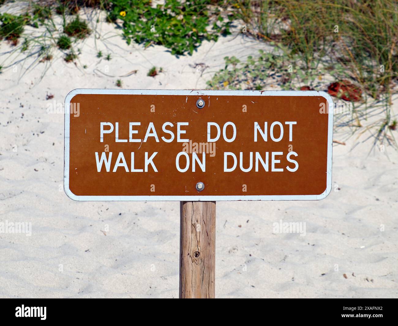 Sand dunes with warning sign. Environmental protection. Close up Stock ...
