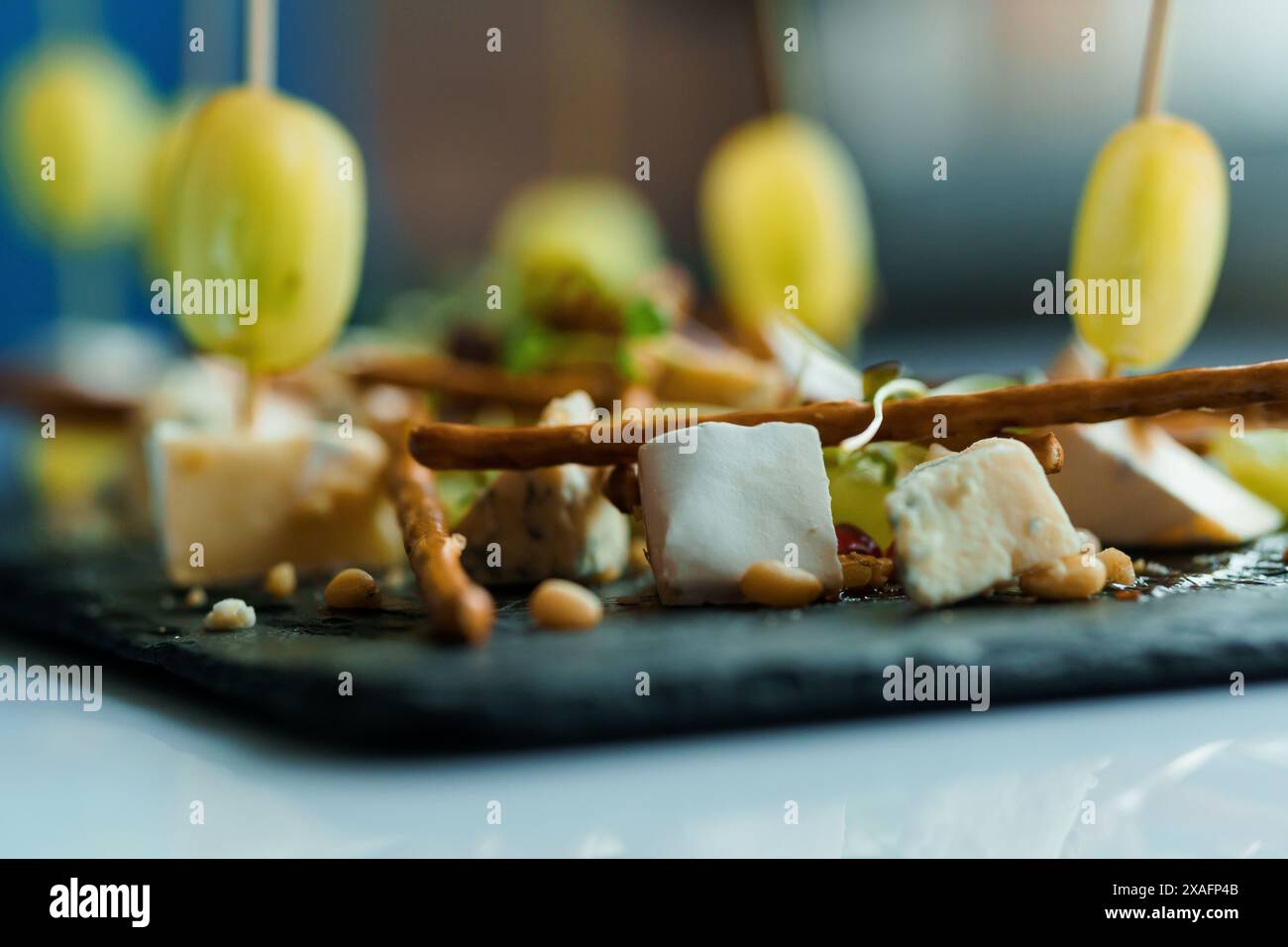 Slicing different types of cheese and grapes. Appetizer with cheese and ...