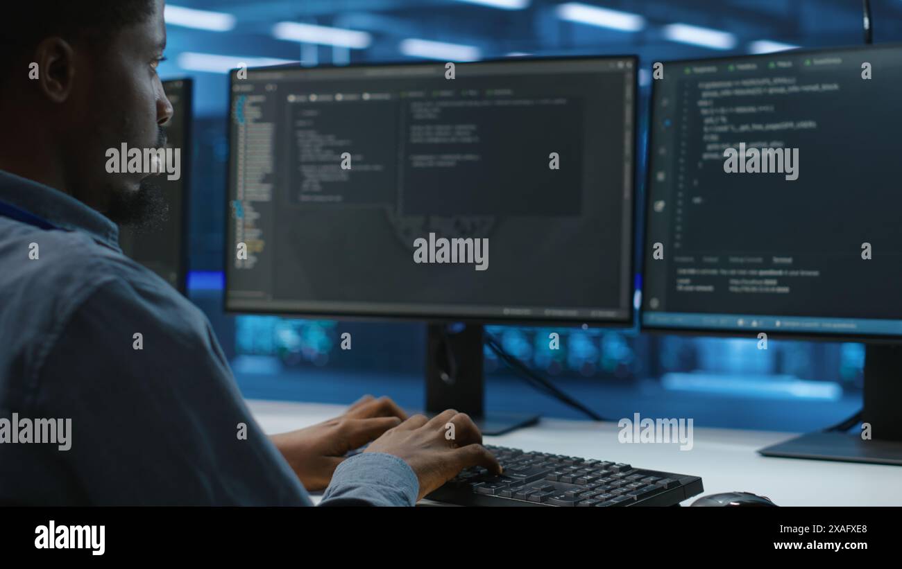 Technician doing system analysis, typing data on PC, doing needed adjustments in supercomputers ...