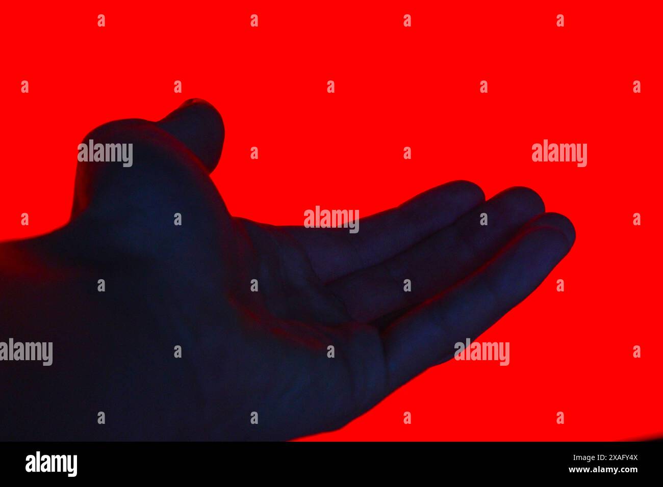 A white hand reaching out to a red background Stock Photo - Alamy