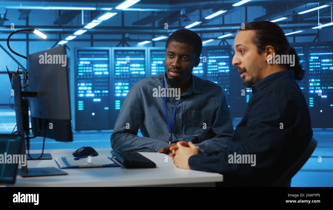 Multiracial Engineers Programming In High Tech Facility With Server Rows Providing Computing 8893
