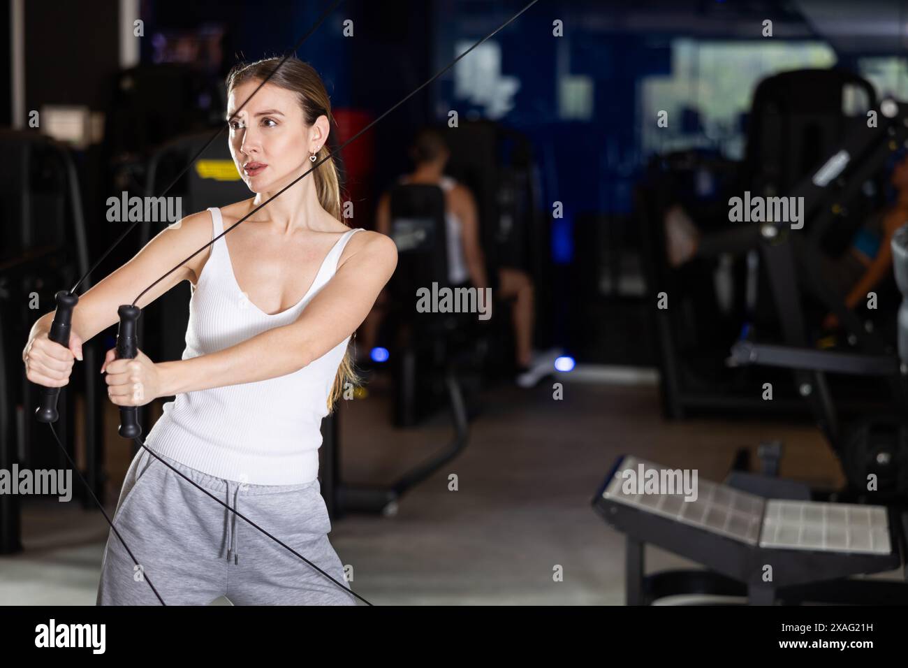 Active athlete young woman during exercises on crossover exercise ...