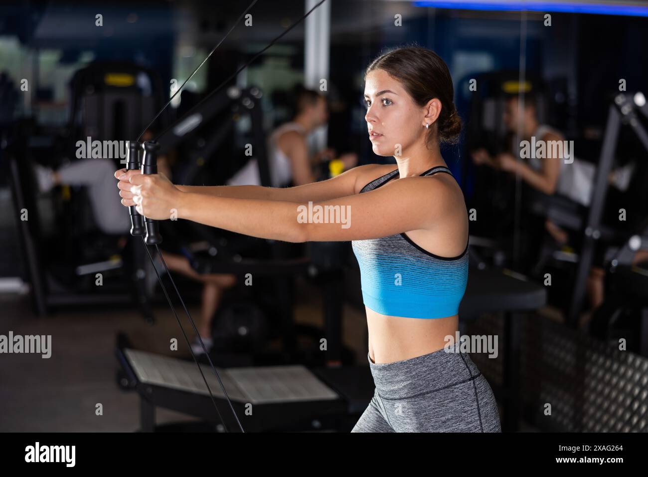 Active athlete young woman during exercises on crossover exercise ...