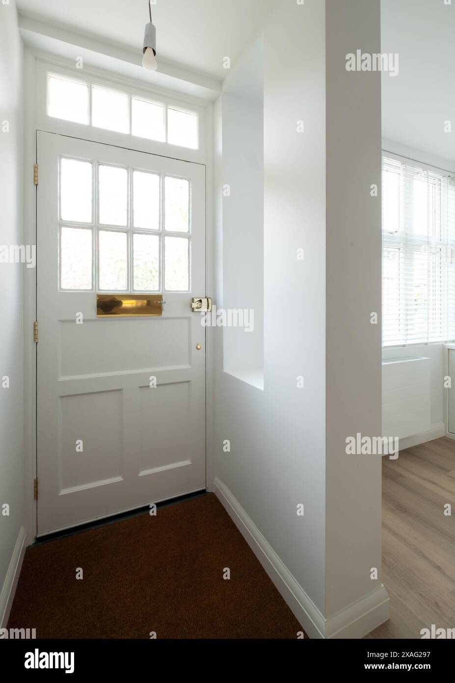 Minimalist, white painted front door and entrance hallway of an ...