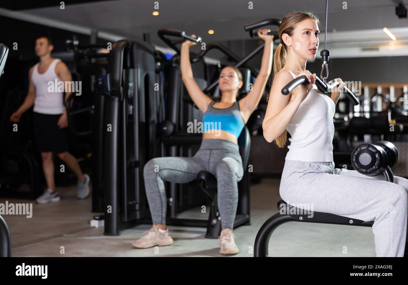 Slender athletic girl work out muscles of arms and shoulders on ...