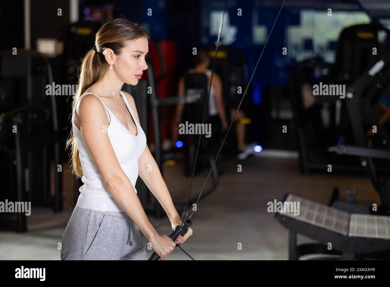 Active athlete young woman during exercises on crossover exercise ...