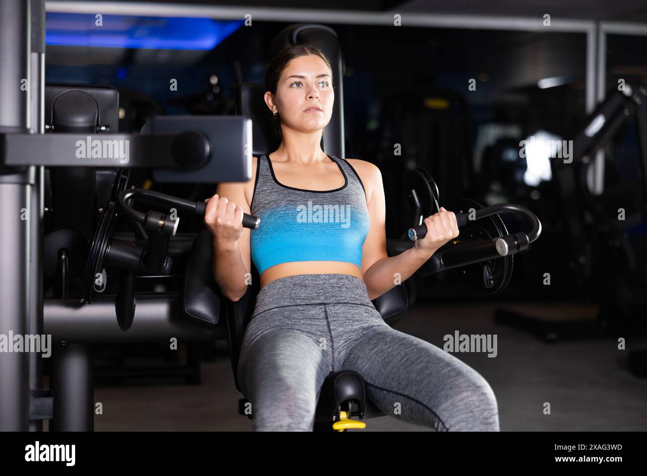 Slender athletic girl work out muscles of arms and shoulders on ...