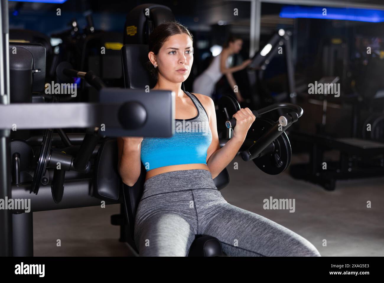 Slender athletic girl work out muscles of arms and shoulders on ...