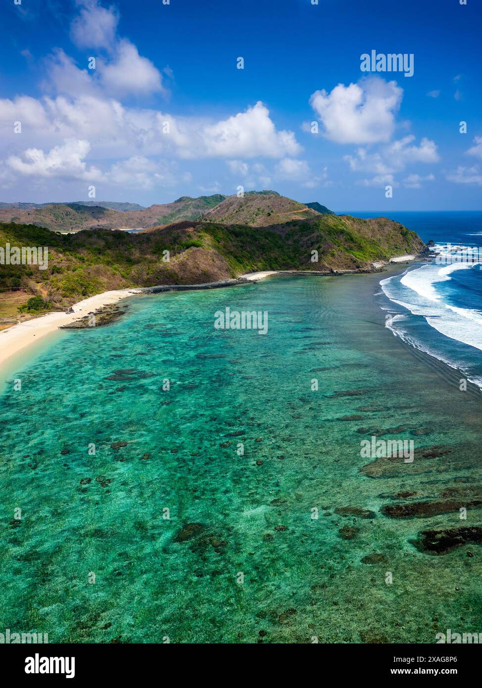 Aerial view of a sandy tropical beach and coral reef surrounded by ...